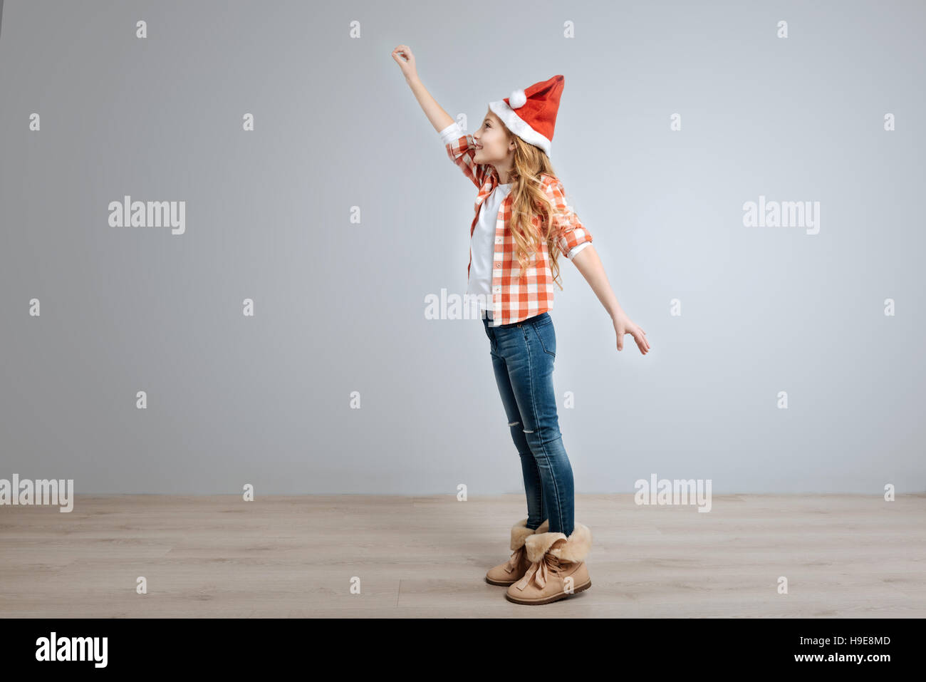 Positive girl standing isolated on grey background Stock Photo - Alamy
