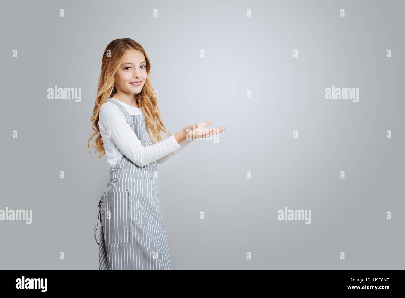 Positive little girl standing isolated on grey background Stock Photo ...