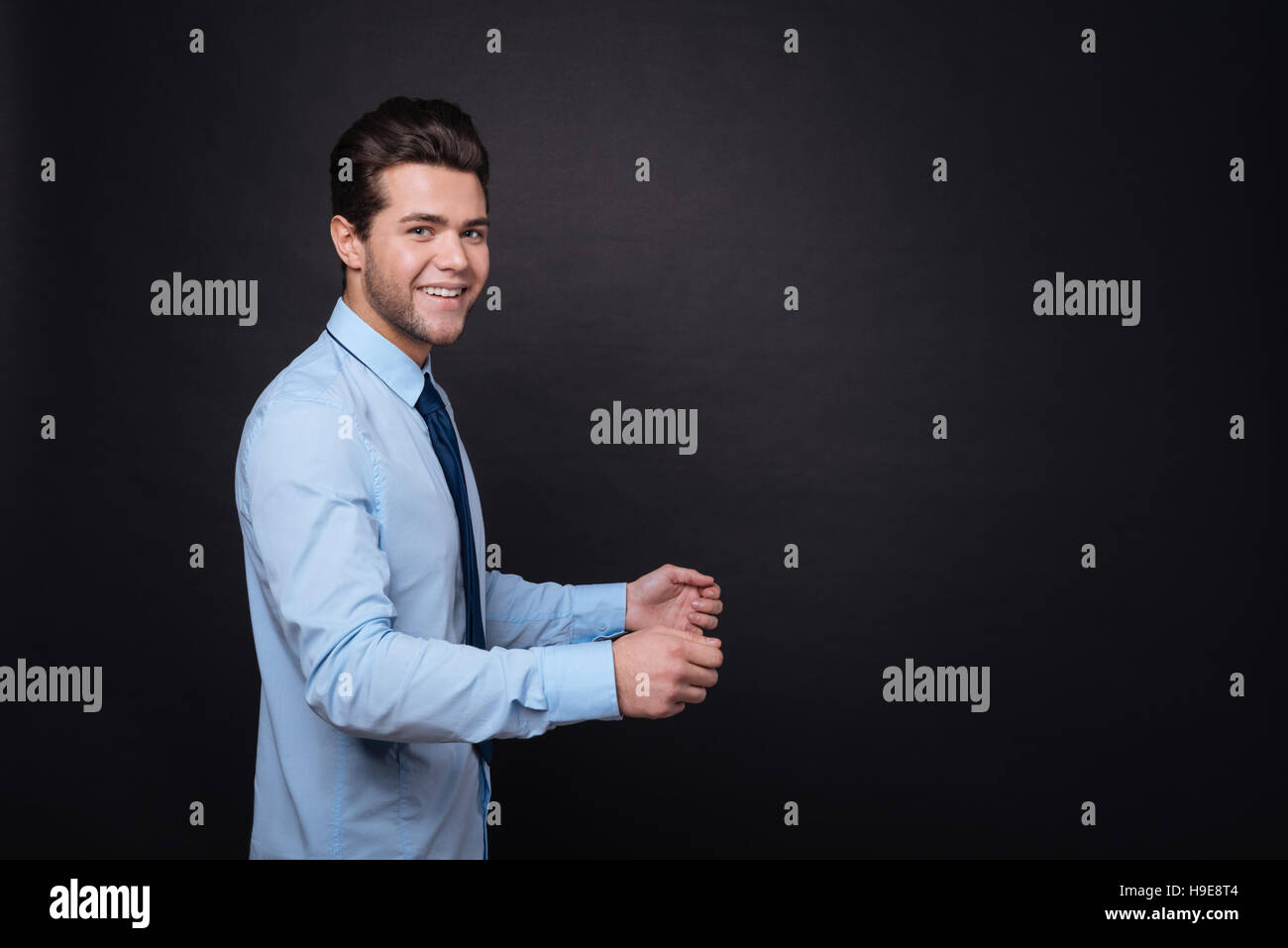 Joyful man expressing gladness on black background Stock Photo - Alamy