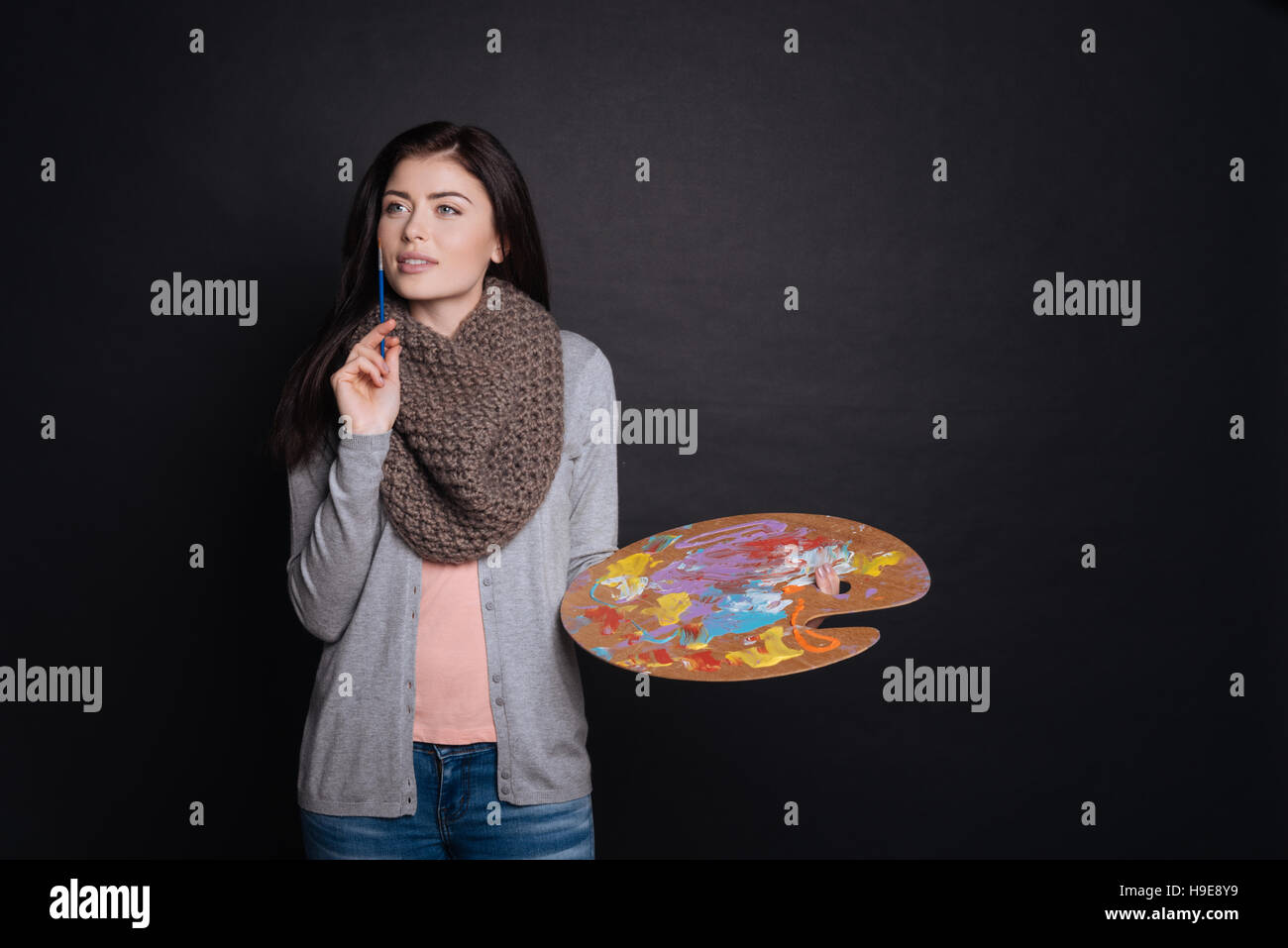 Delighted content female artist thinking Stock Photo - Alamy