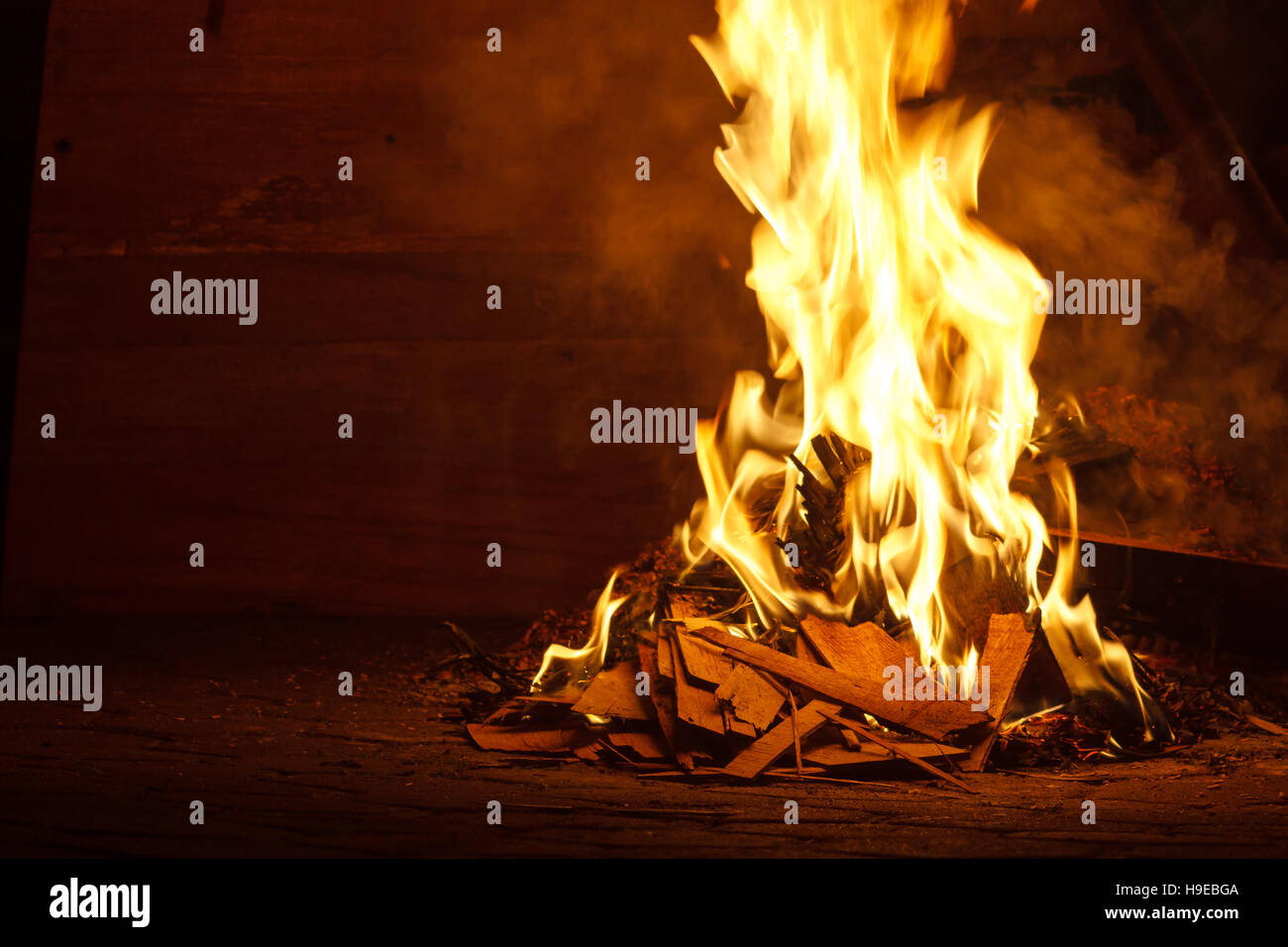 Piles of scrap wood waste are burning on fire Stock Photo - Alamy