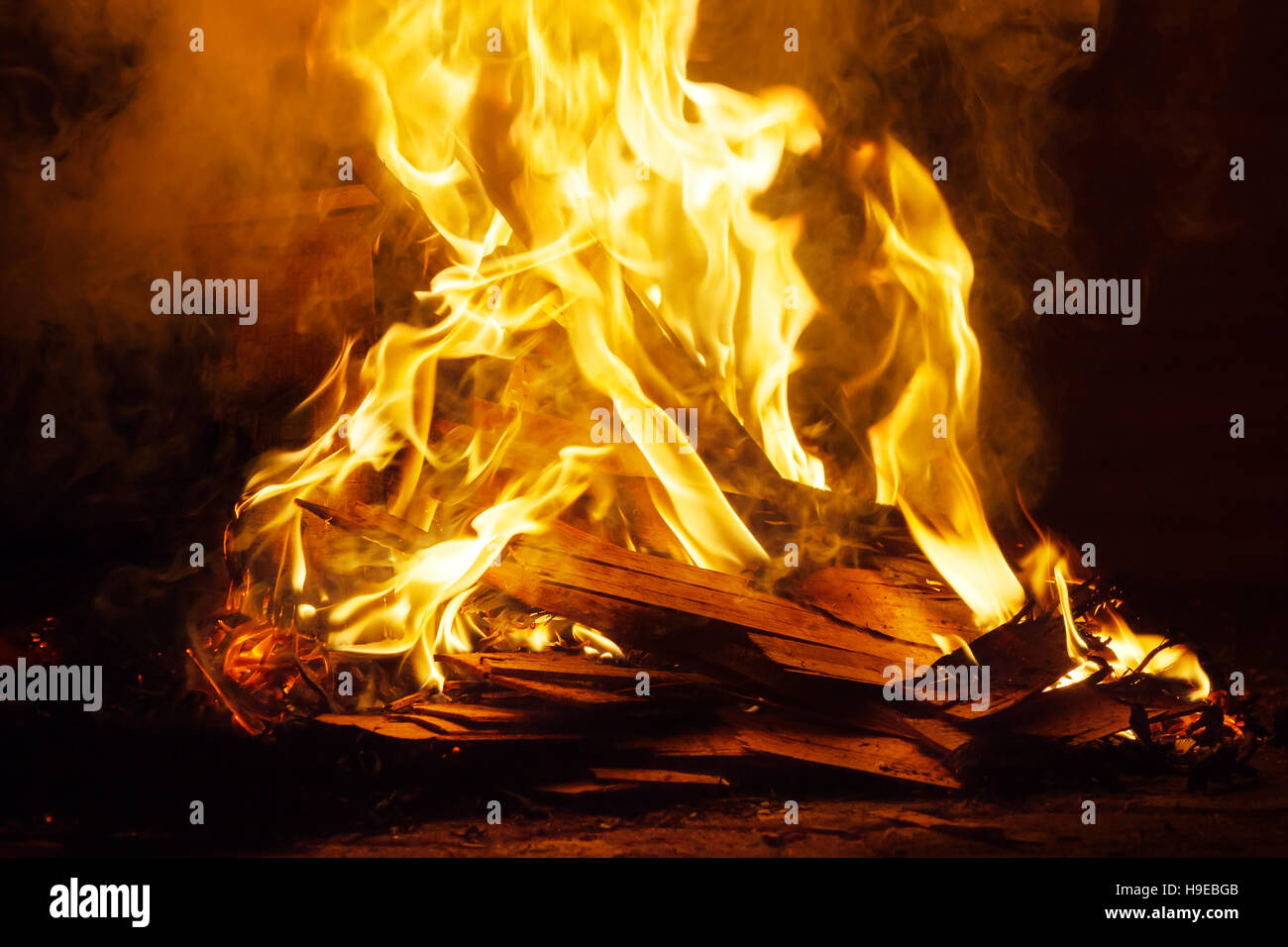 Piles of scrap wood waste are burning on fire Stock Photo - Alamy