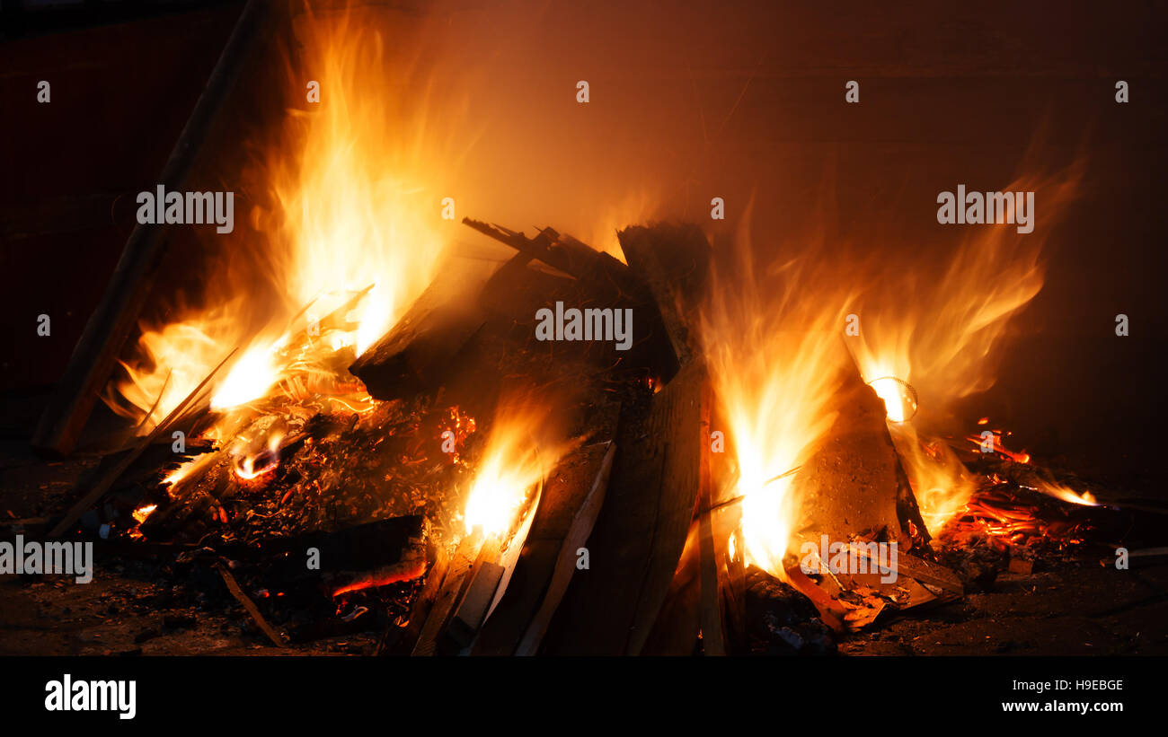 Piles of scrap wood waste are burning on fire. Long exposure ...