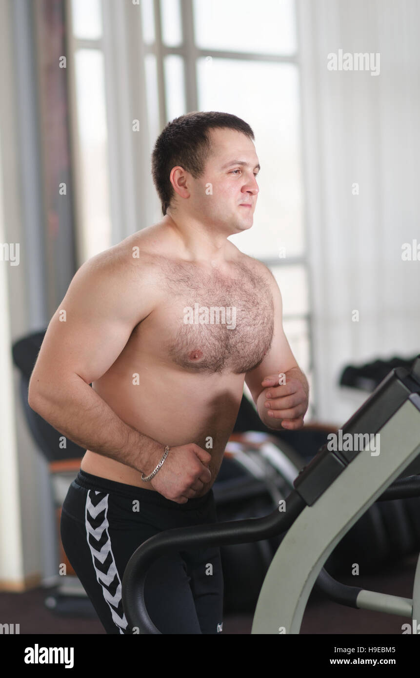 Young man running on treadmill in gym hi-res stock photography and ...