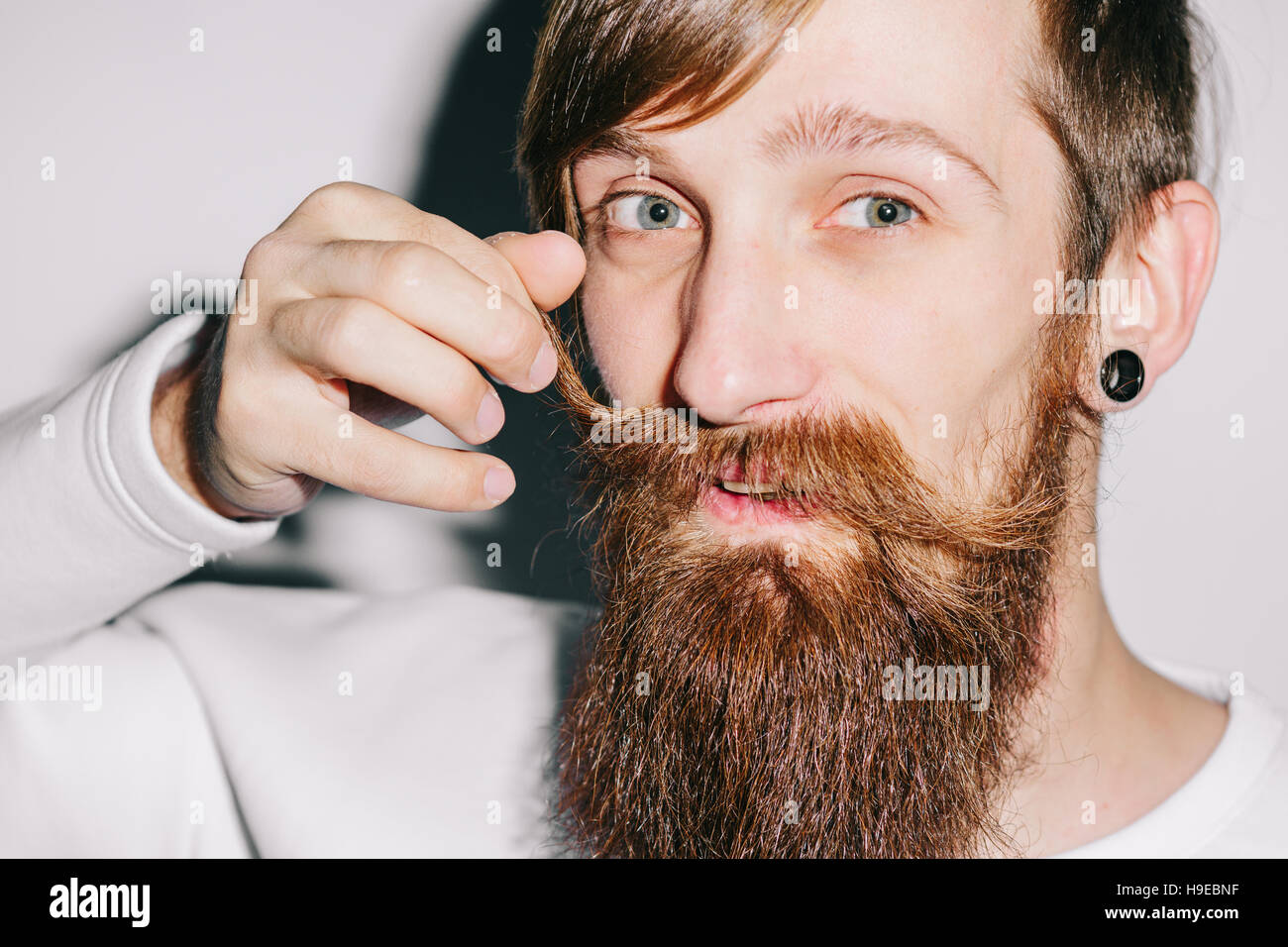 Bearded man twirling his mustache Stock Photo - Alamy