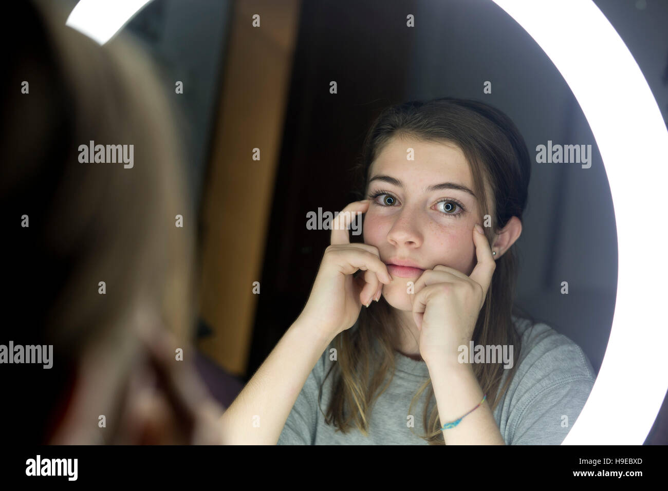 Portrait of teenage looking in a mirror, with the sad and serious face ...