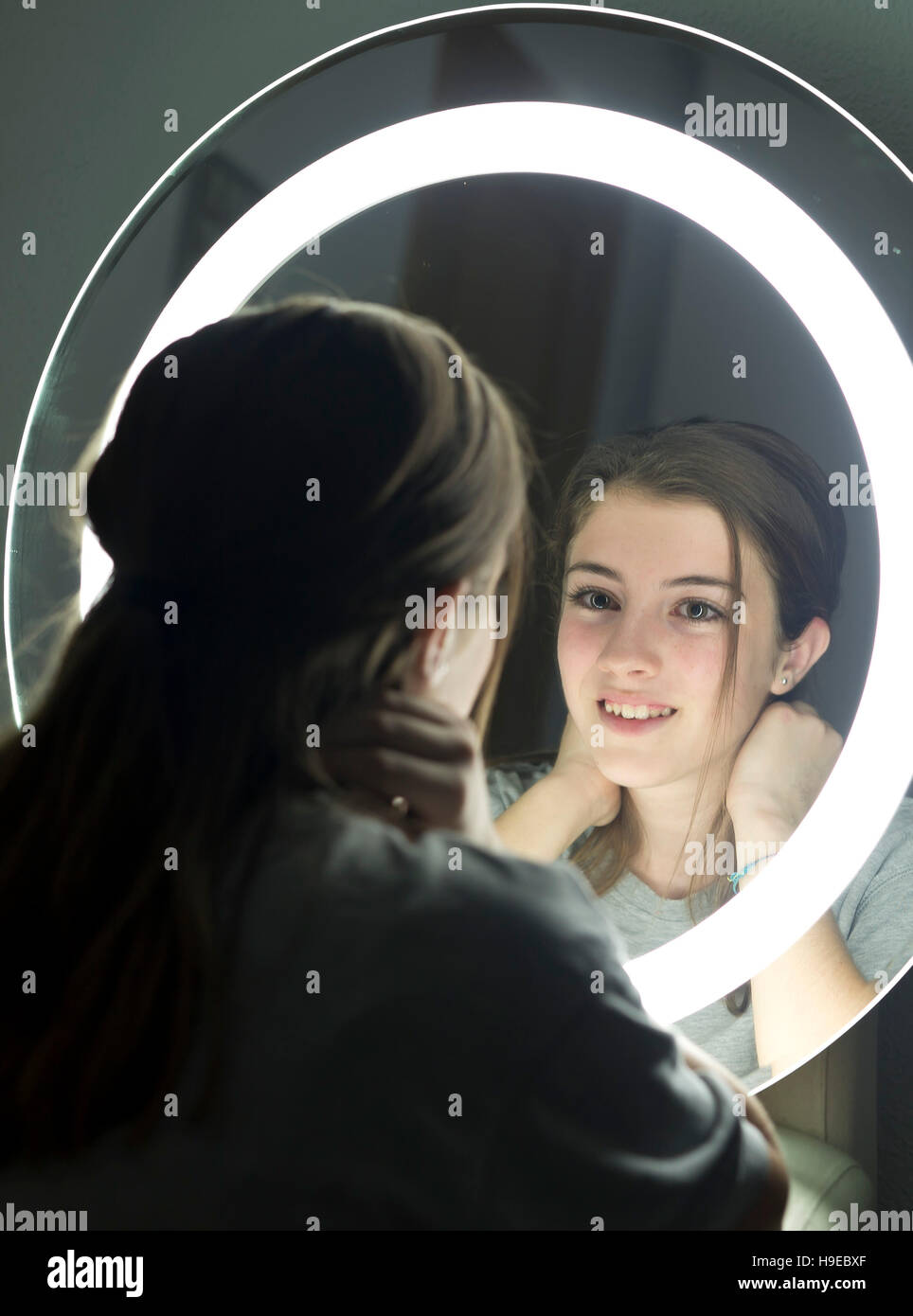 Portrait of teenage looking in a mirror, with a smile on your face ...