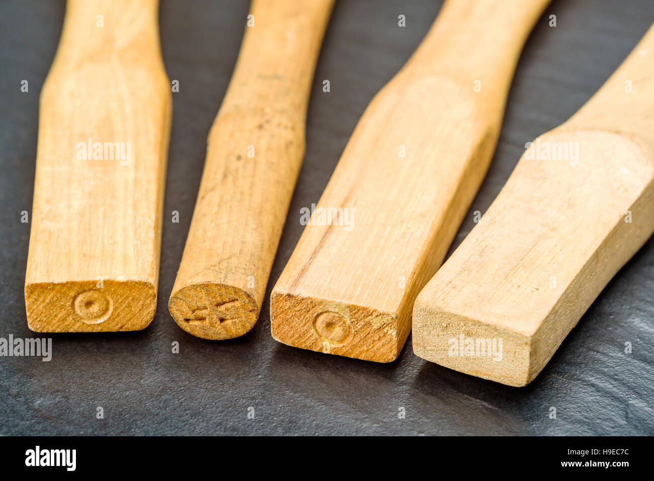 Spare wooden handles or shafts on dark background Stock Photo - Alamy