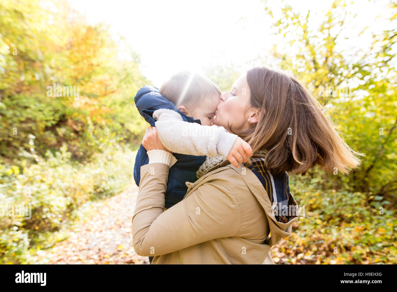 Beautiful young mother with her son in autumn forest Stock Photo - Alamy