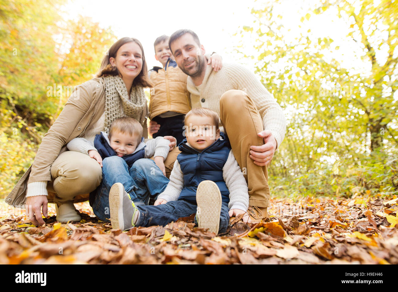 Beautiful young family on a walk in autumn forest Stock Photo - Alamy