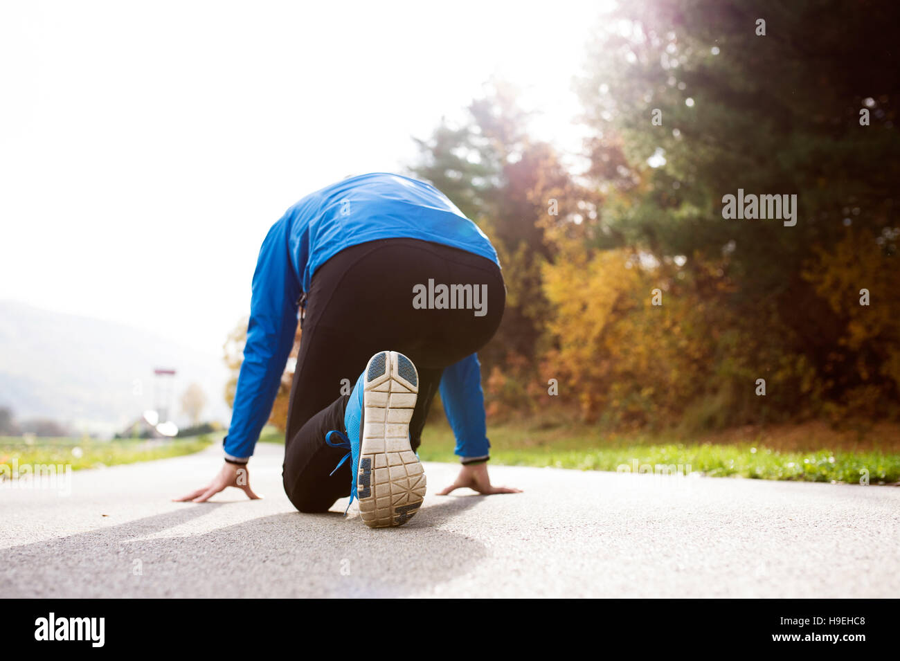 Runner at the lake on asphalt path in steady position Stock Photo - Alamy