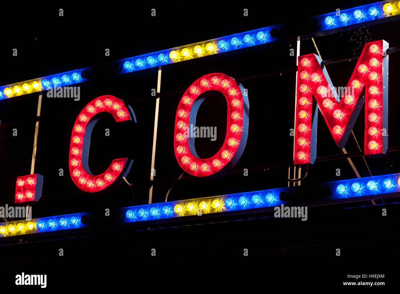 electric .COM sign on a scaffolding in circus-style during the night ...