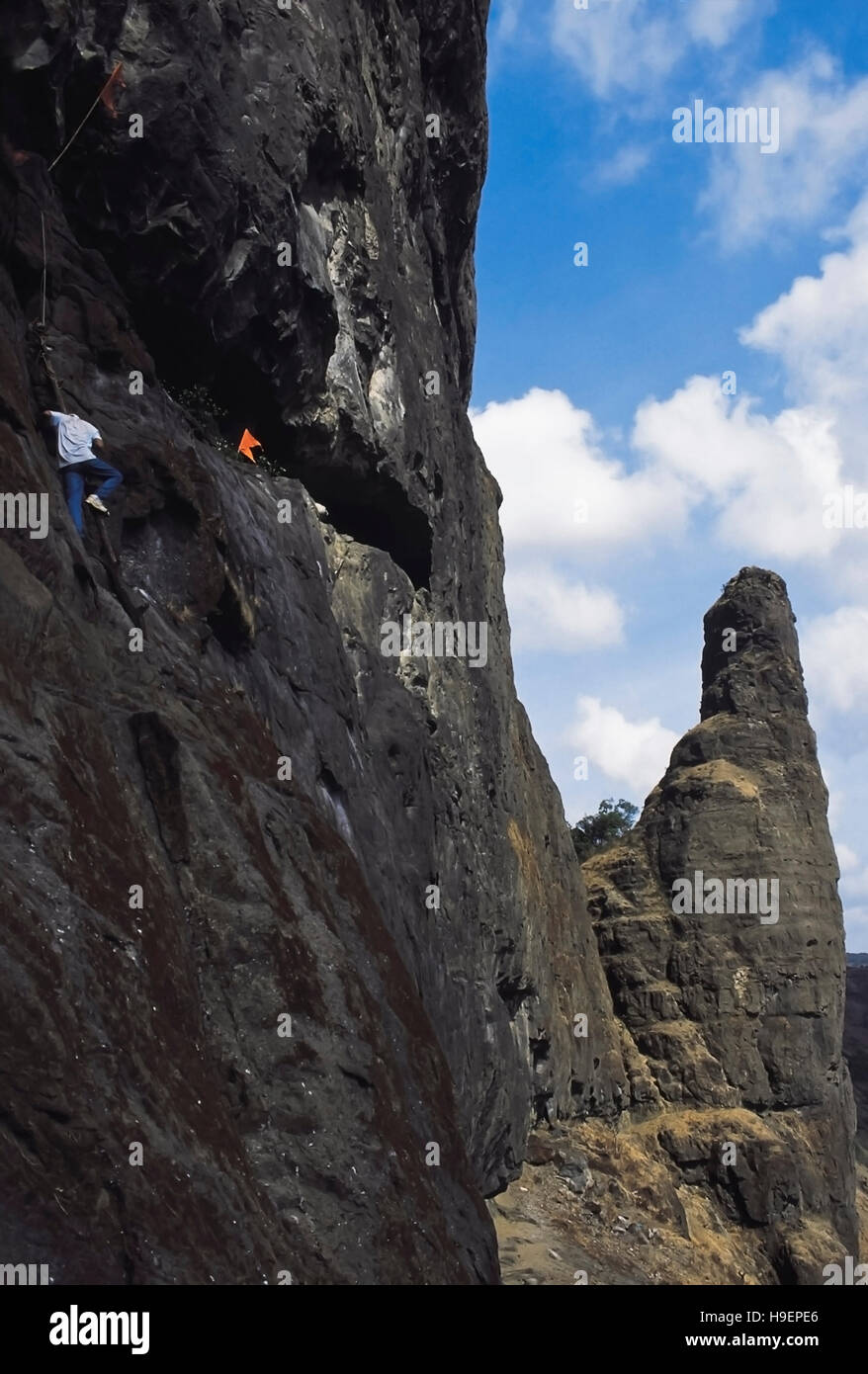 Climber entering a basalt cave at Gada Chi-Bahiri, near Lonavla ...