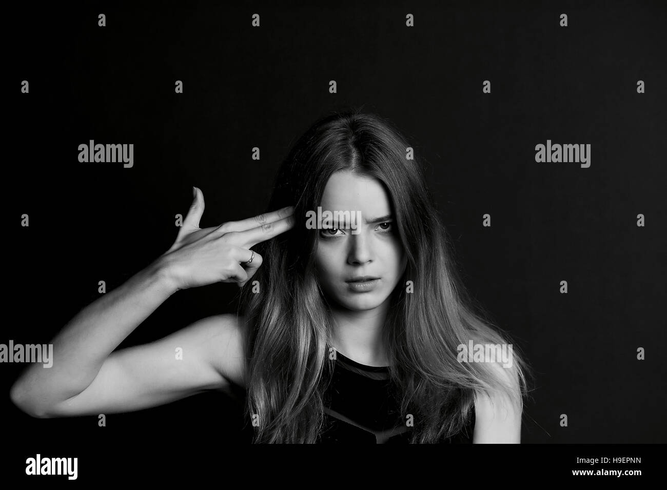 Beautiful girl. The gesture of fingers the gun Stock Photo - Alamy