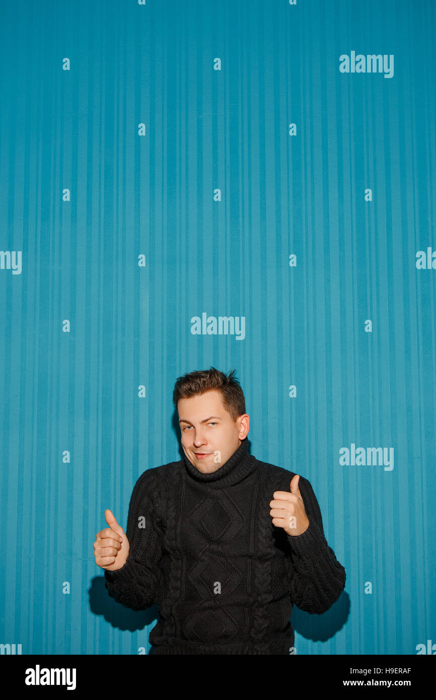 Portrait of young man with serious facial expression showing OK over ...