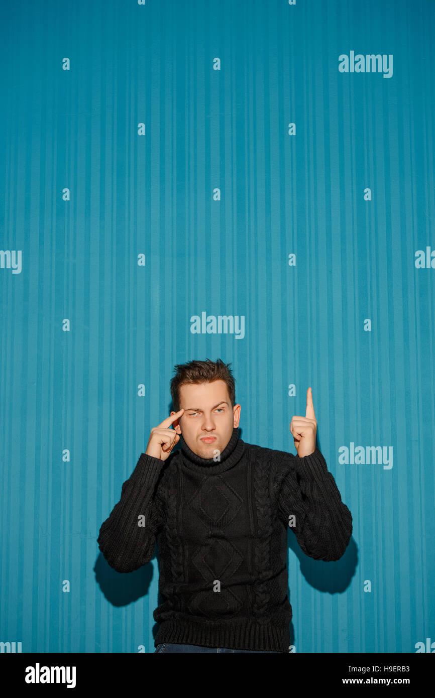 Portrait of young man with serious facial expression showing up over ...