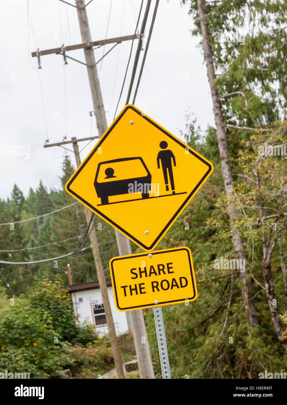 A road sign in Canada showing a car and pedestrian walking on the road ...
