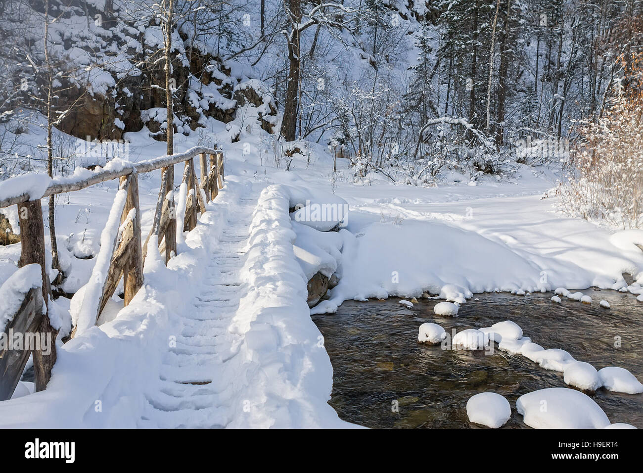 Wooden bridge over the river in snow in winter forest Stock Photo - Alamy