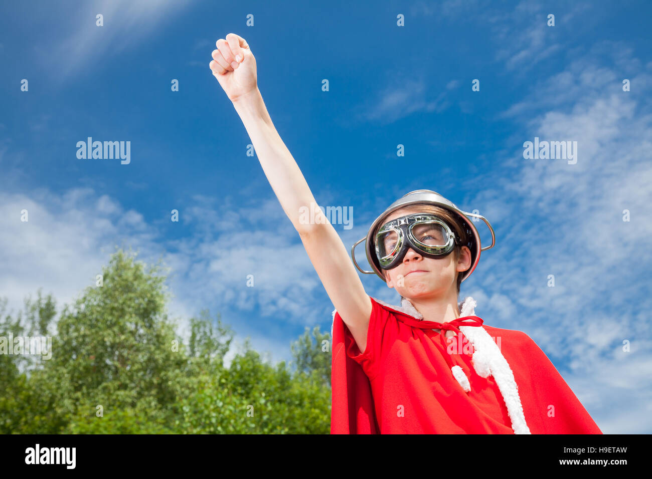 Low angle view of cute teenage boy wearing metal colander as a helmet ...