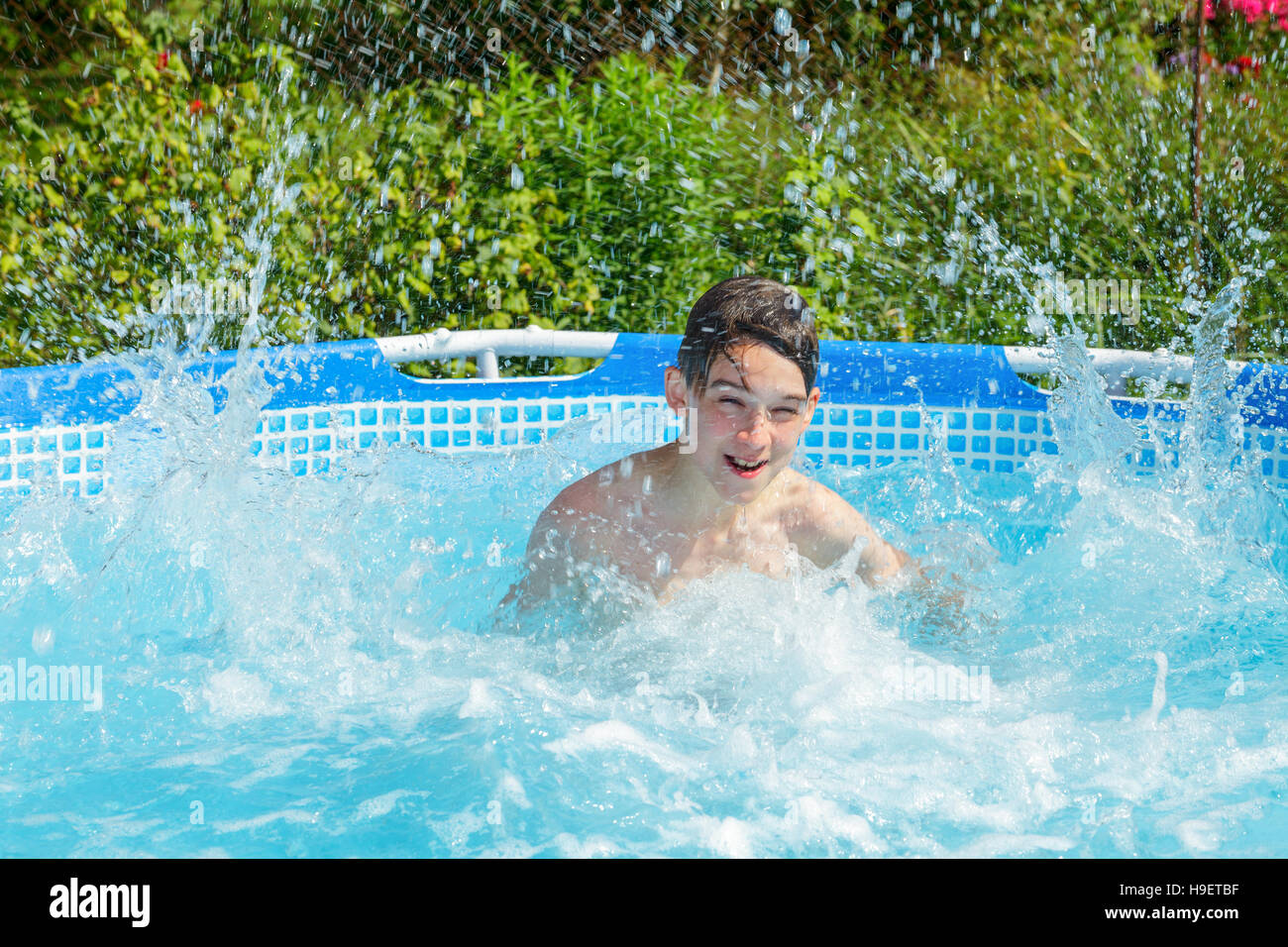 Cute teen boy enjoying summer splashing water in a swimming pool Stock ...