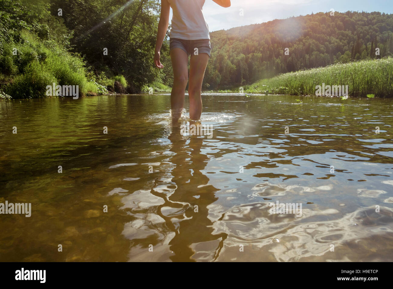 Caucasian woman wading in river Stock Photo - Alamy