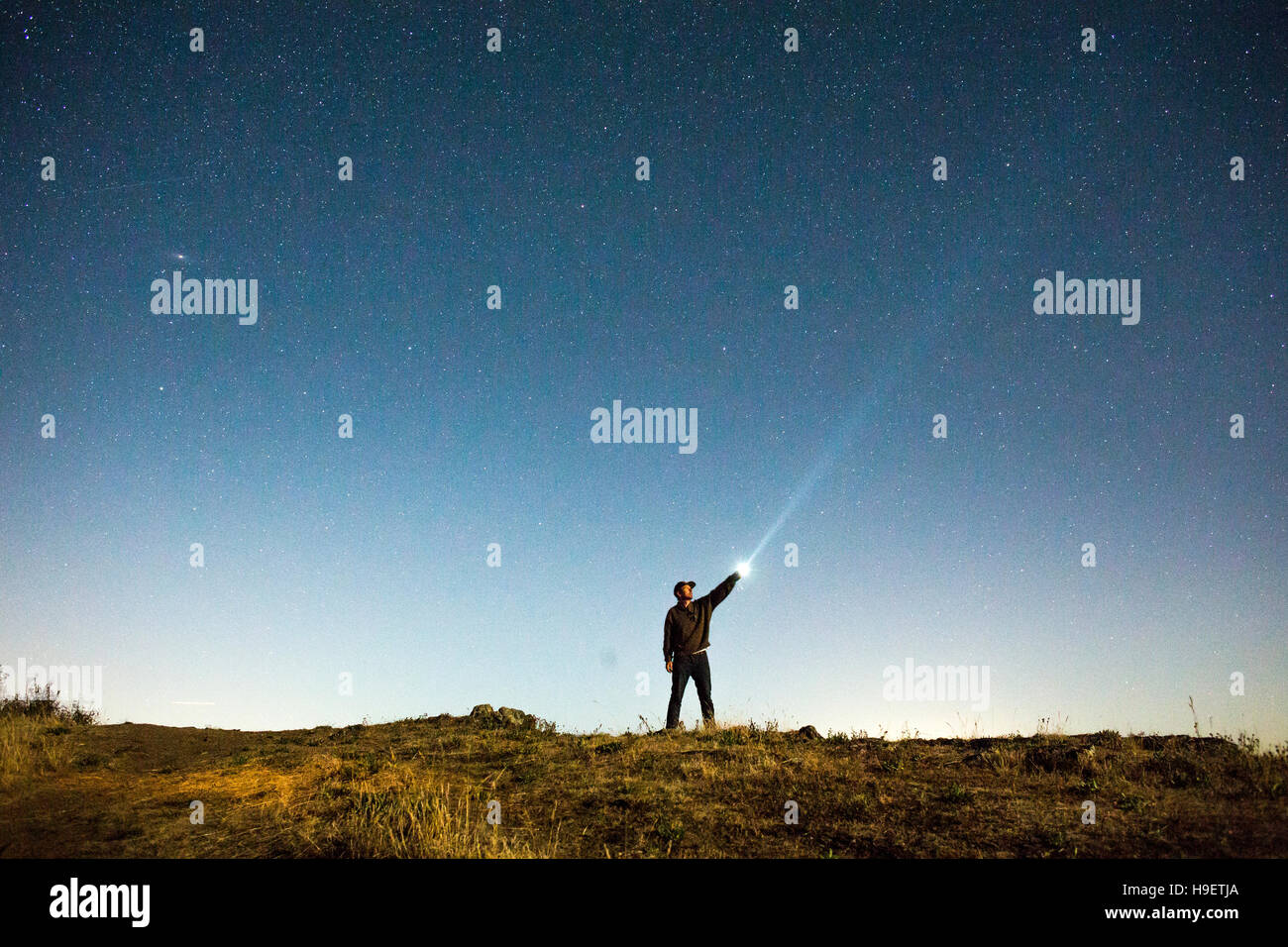 Caucasian man pointing flashlight at night sky Stock Photo - Alamy