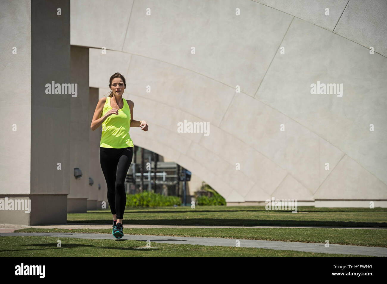 Caucasian woman running near pillars Stock Photo - Alamy