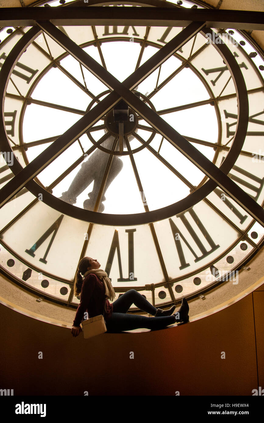 Girl sitting in clock window Stock Photo - Alamy