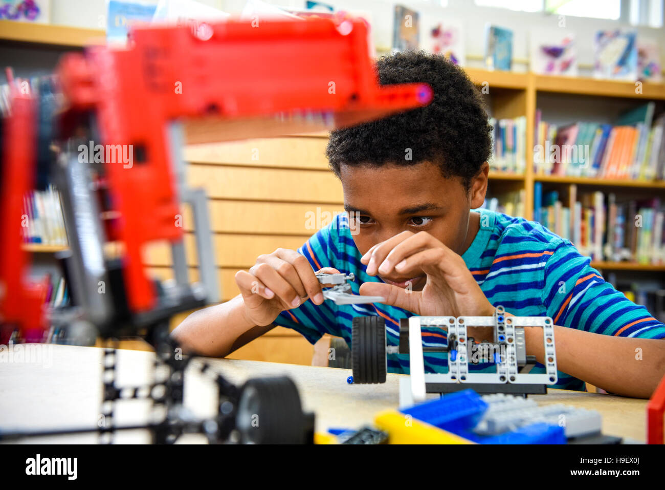 Boy assembling plastic blocks in library Stock Photo - Alamy