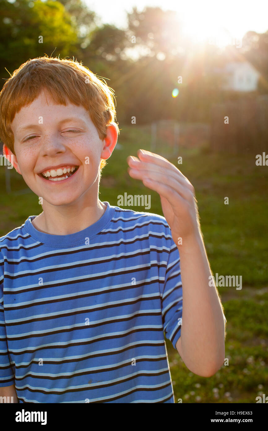 Smiling Caucasian boy laughing in sunny backyard Stock Photo - Alamy