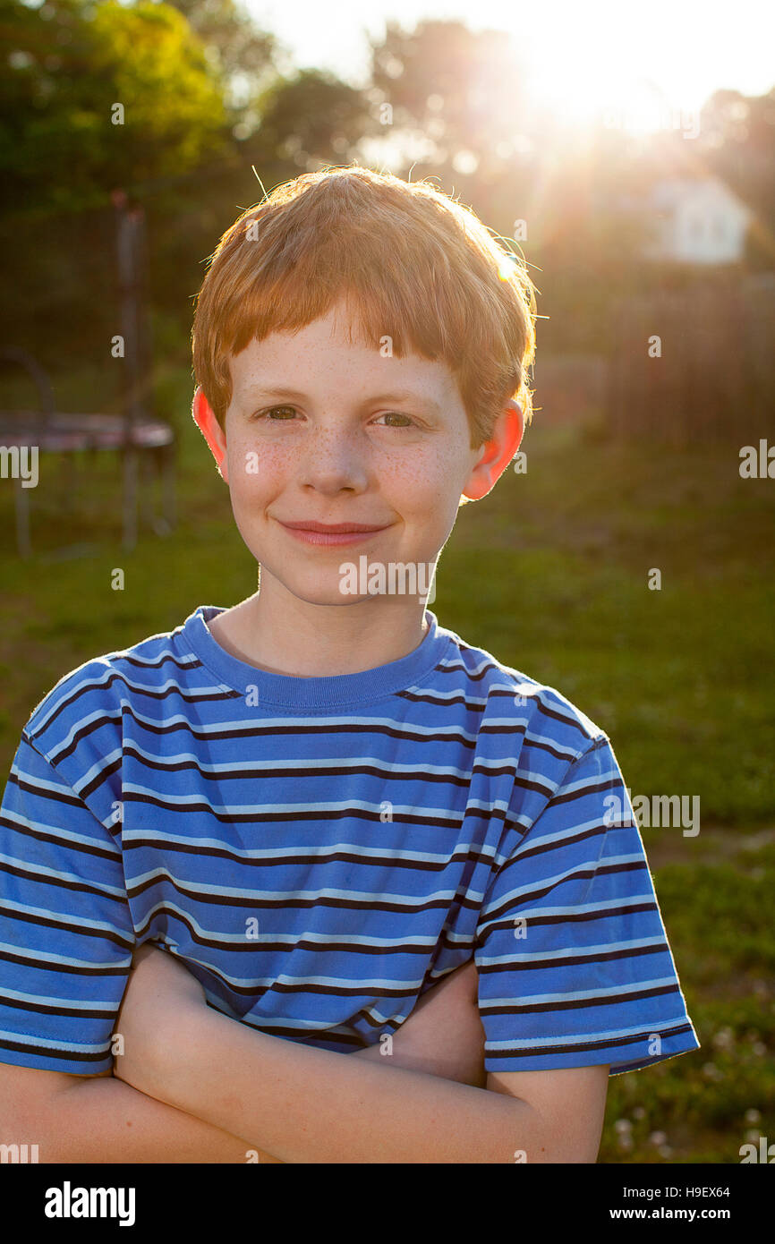Smiling Caucasian boy standing in sunny backyard Stock Photo - Alamy