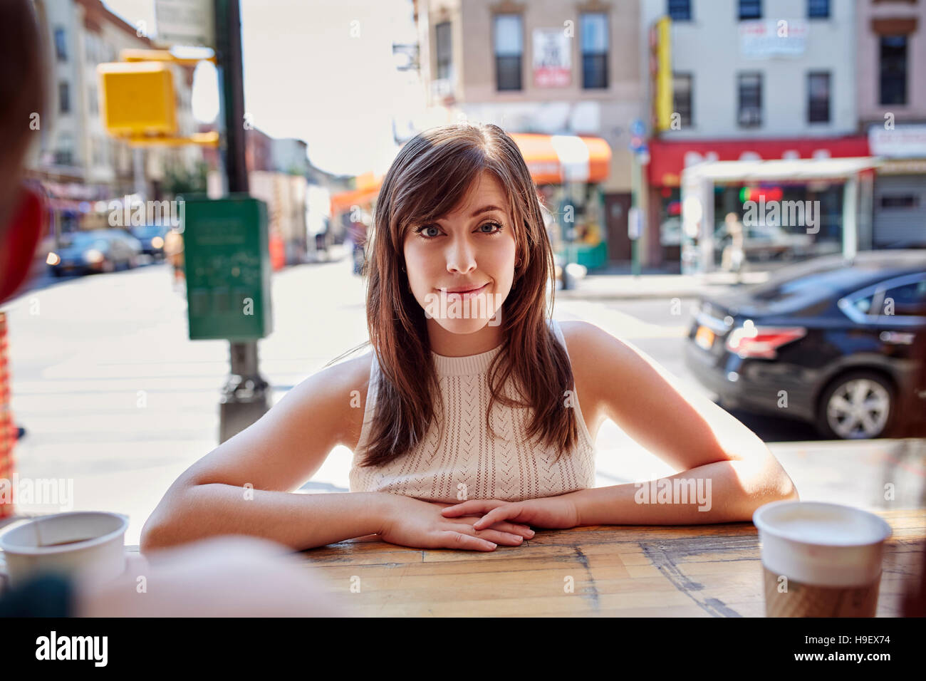 Smiling Caucasian woman leaning on counter in city Stock Photo - Alamy