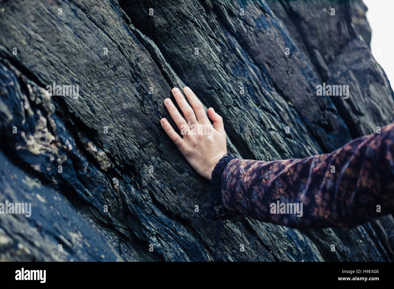 A young female hand wearing a wedding ring is touching the side of a ...