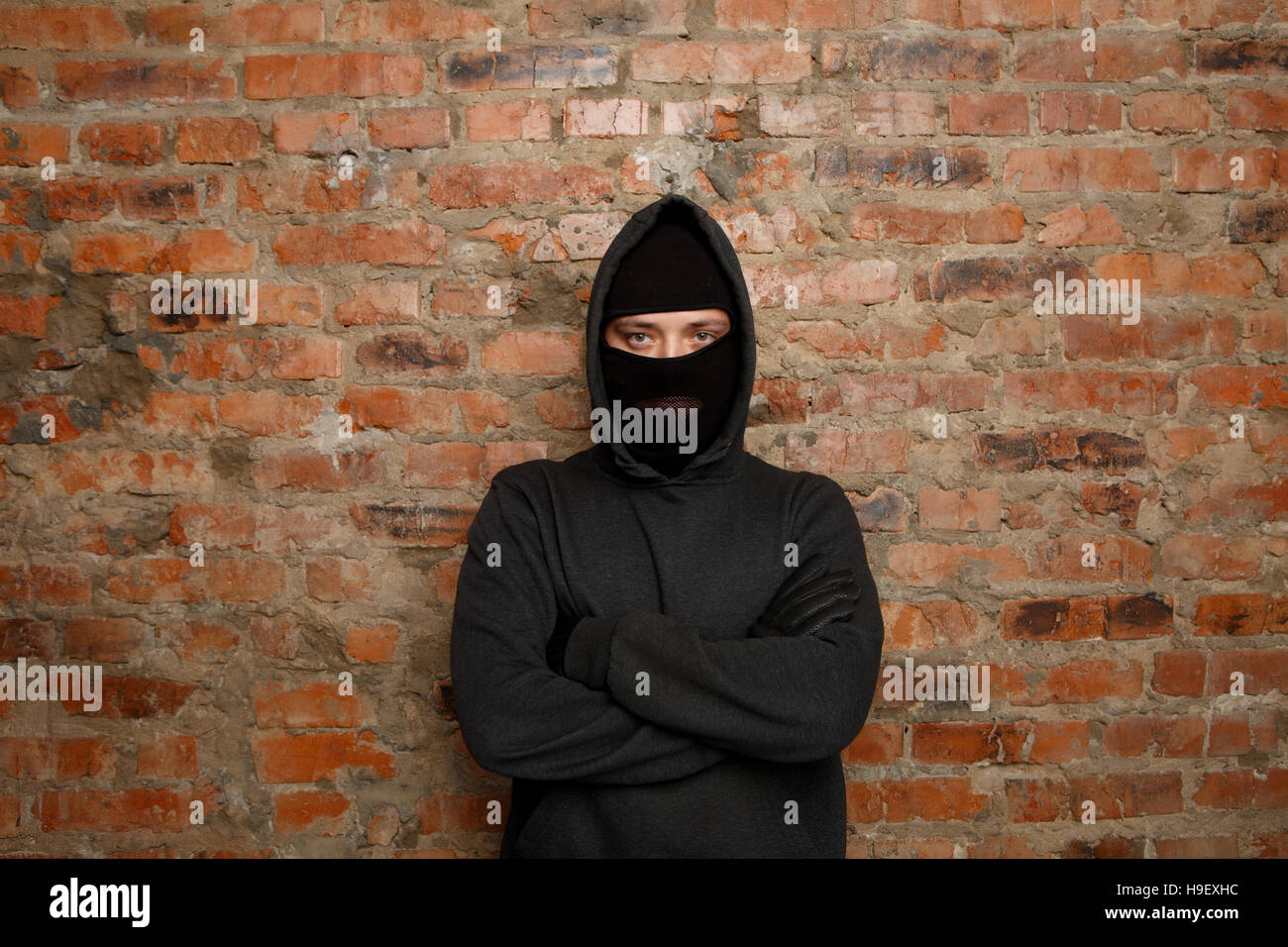 Serious thief with crossed arms Stock Photo - Alamy