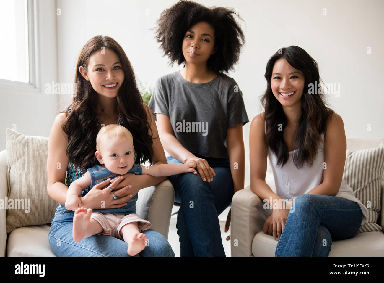 Portrait of smiling friends with baby Stock Photo - Alamy