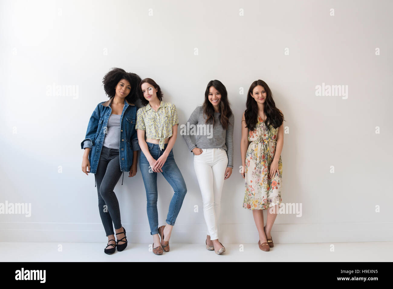 Portrait of smiling women leaning on wall Stock Photo - Alamy
