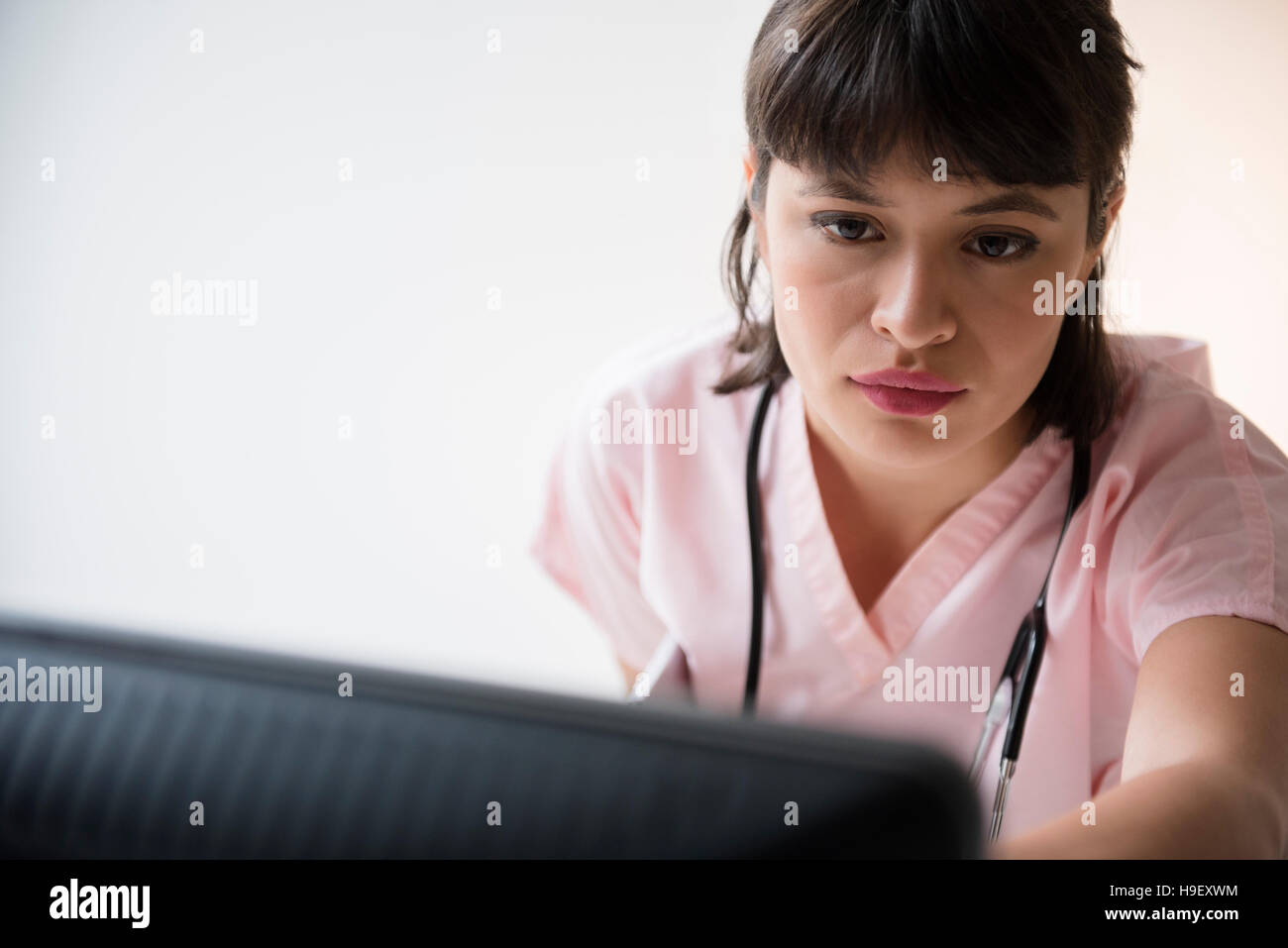 Hispanic nurse using computer Stock Photo - Alamy