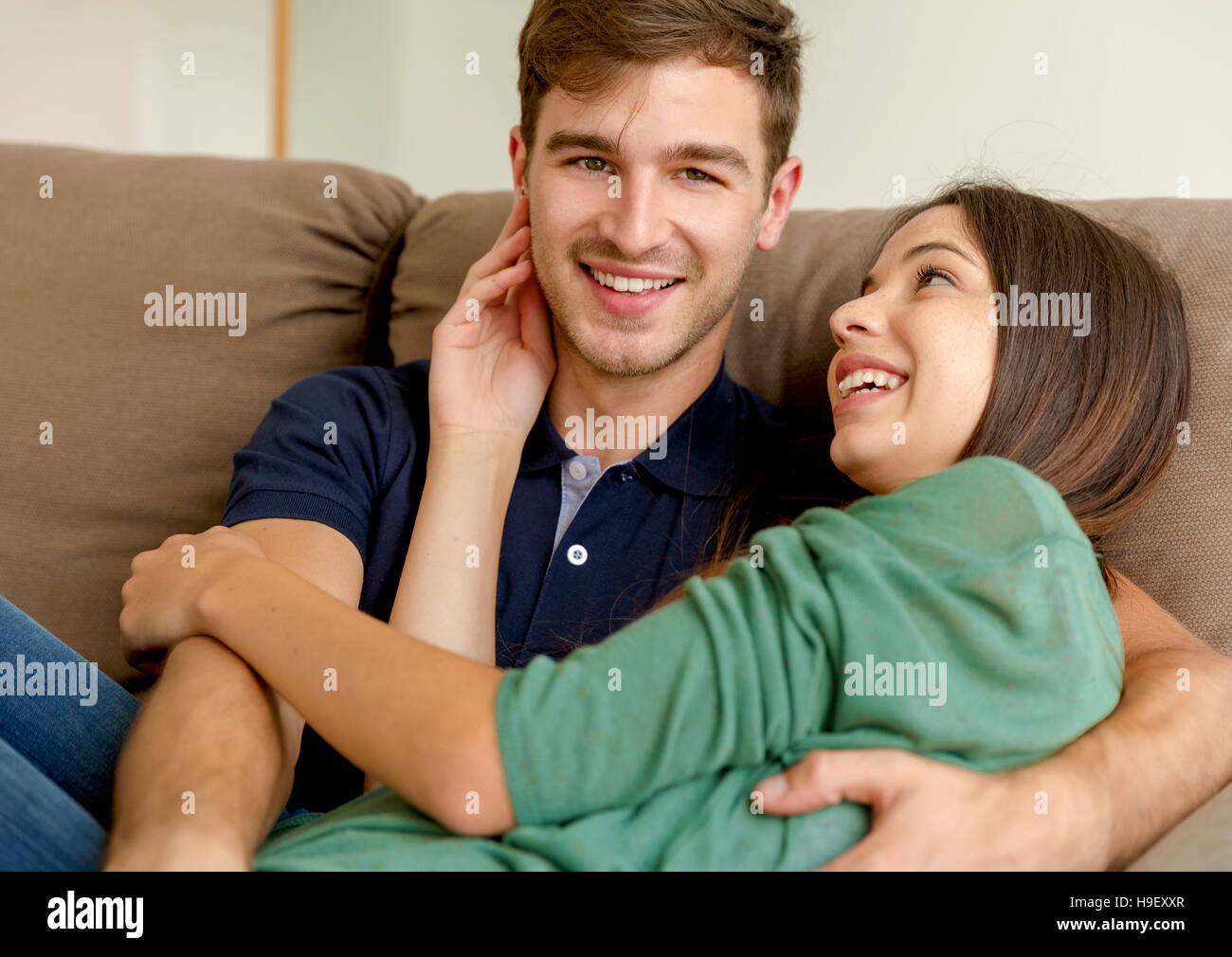 Young couple sitting on the sofa and dating Stock Photo - Alamy