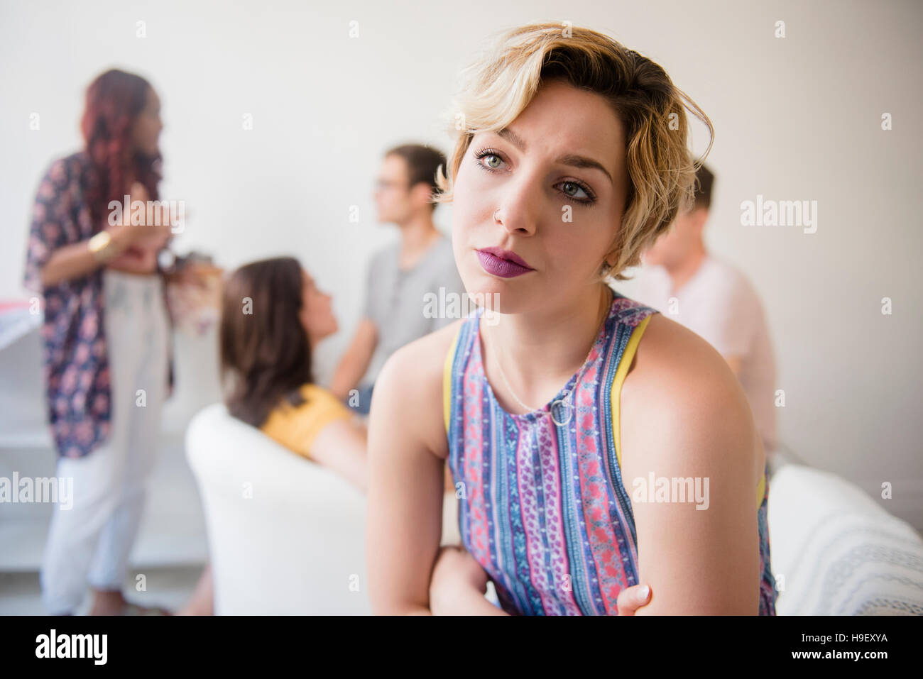 Portrait of woman sulking at party Stock Photo - Alamy