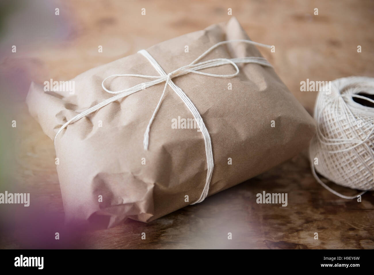 String tied around package wrapped in brown paper Stock Photo - Alamy