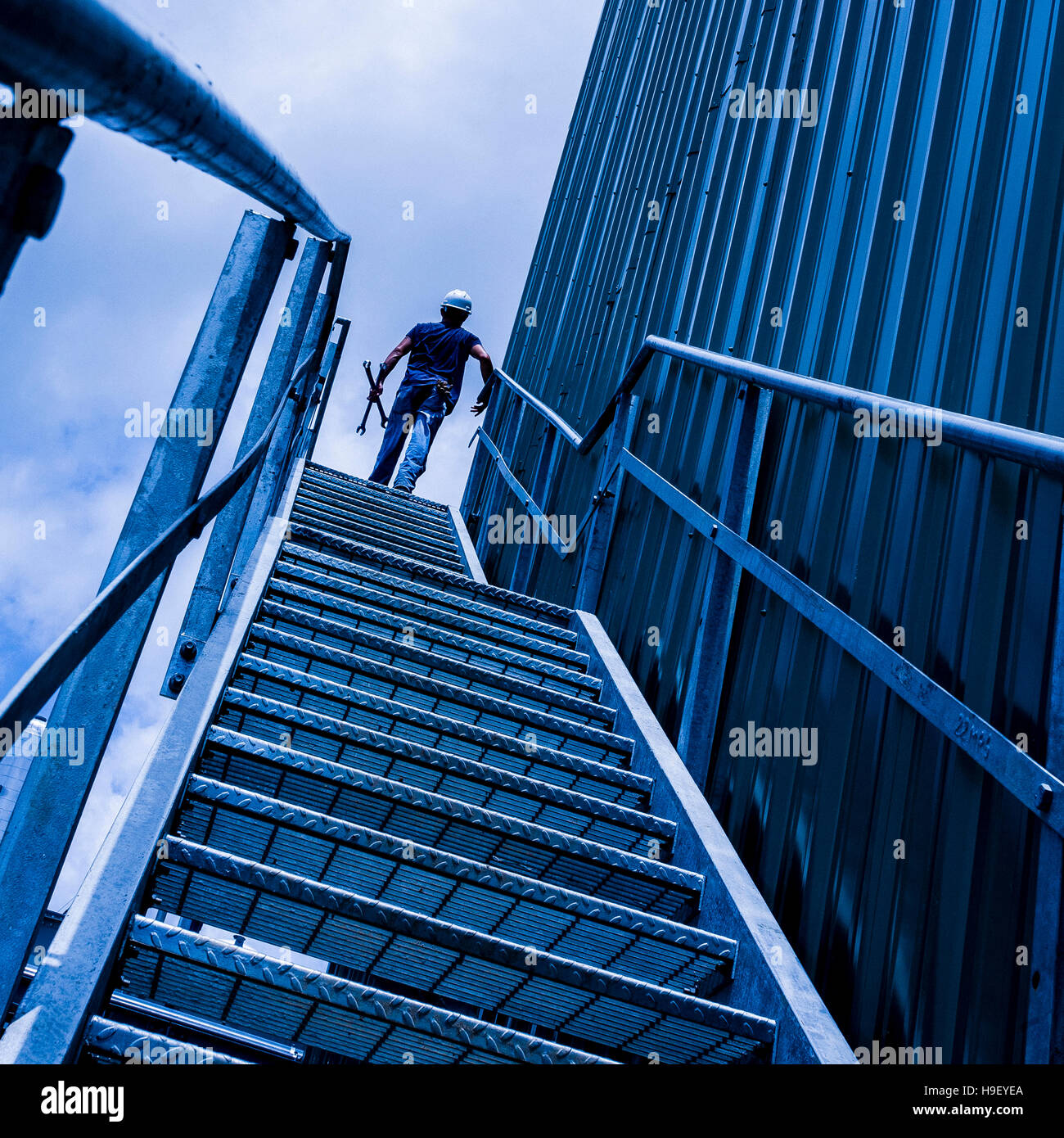 Caucasian worker carrying tools on staircase Stock Photo - Alamy