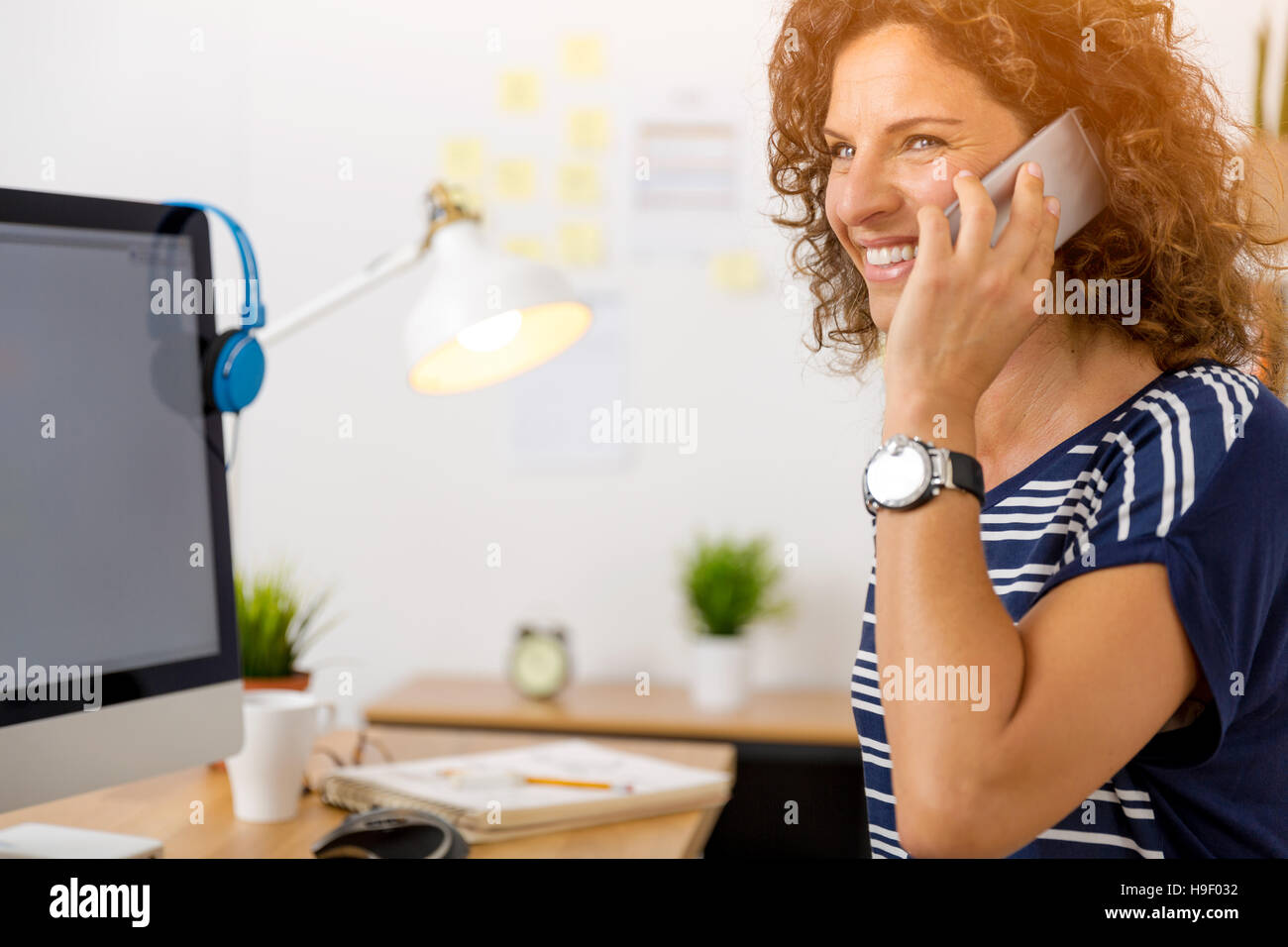 Middle aged woman at office making a phone call Stock Photo - Alamy