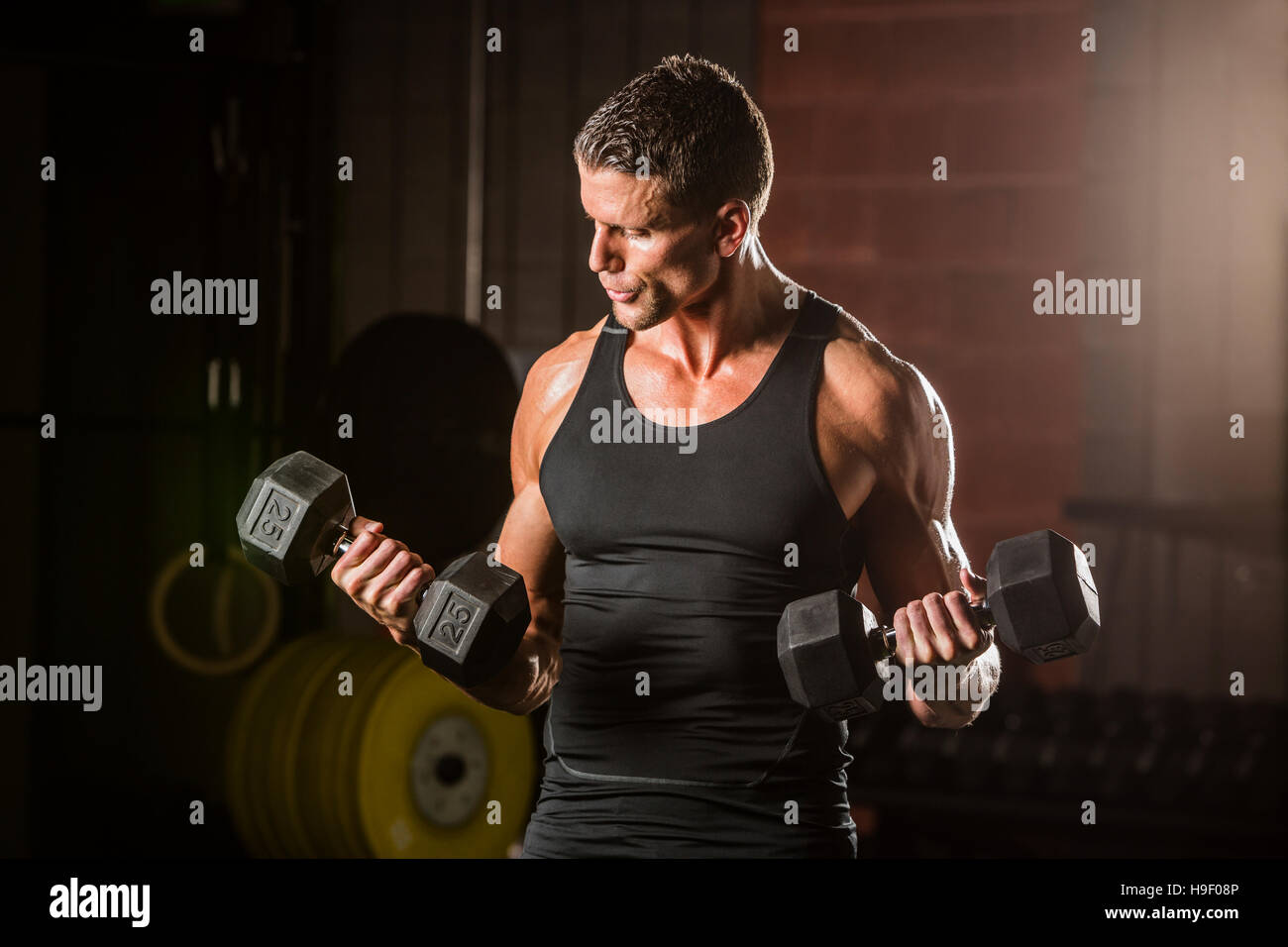 Serious muscular man lifting dumbbells hi-res stock photography and ...