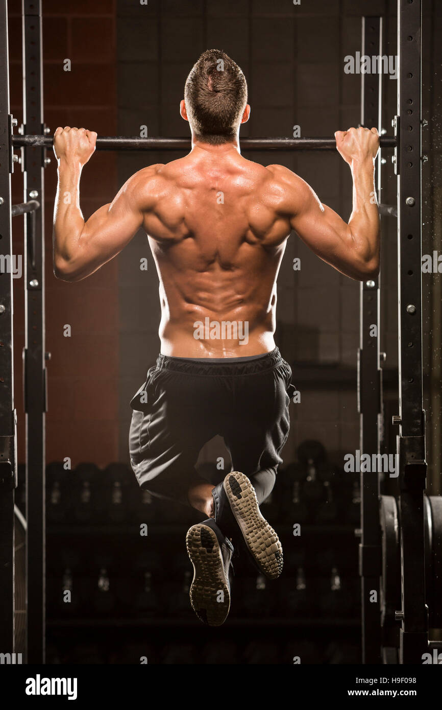 Caucasian man doing chin-up in gymnasium Stock Photo - Alamy