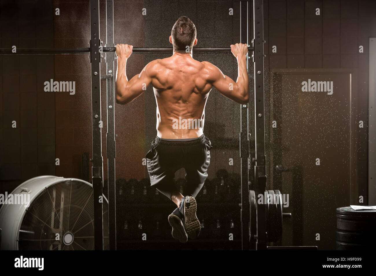 Caucasian man doing chin-up in gymnasium Stock Photo - Alamy