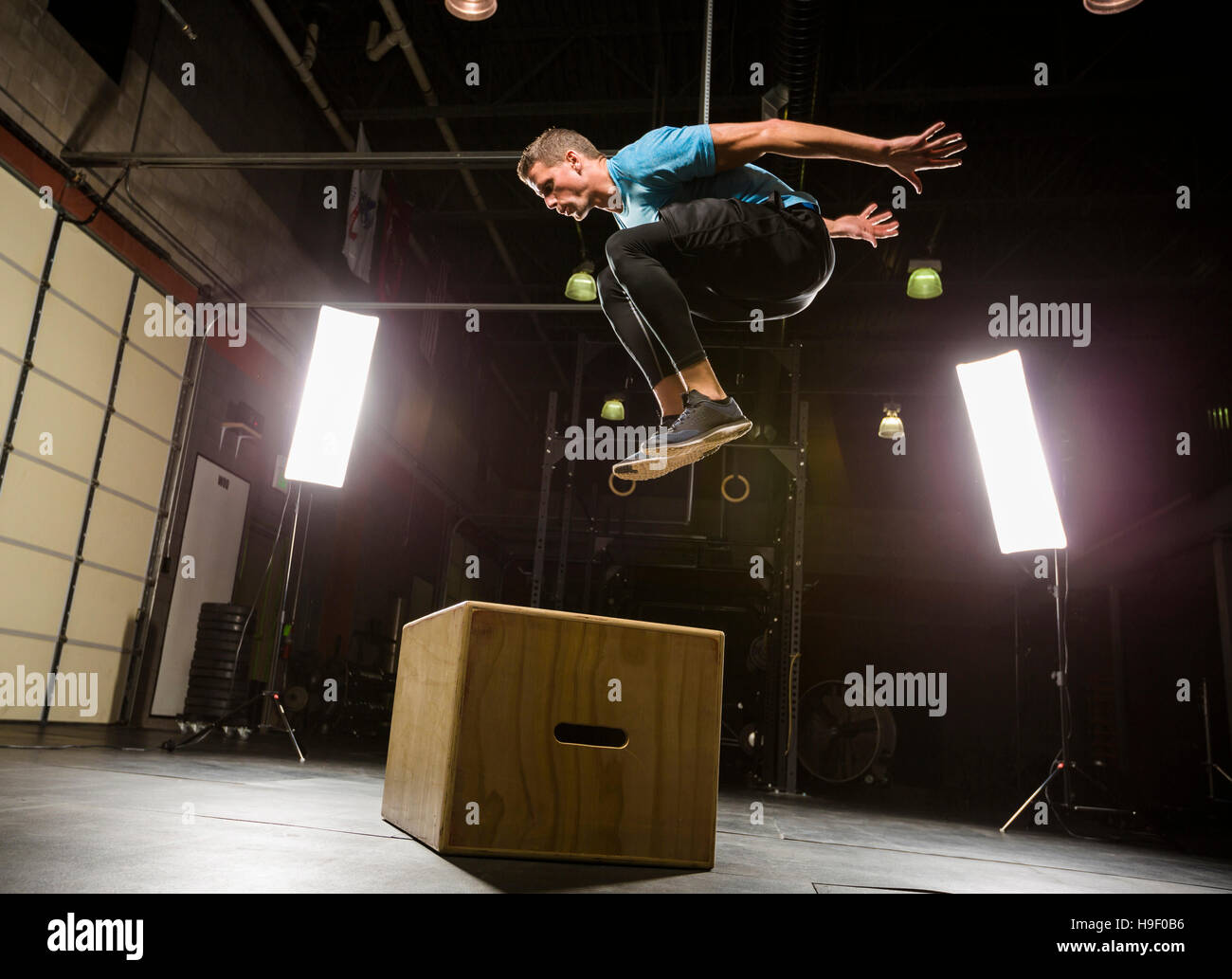 Caucasian man jumping on box in gymnasium Stock Photo - Alamy