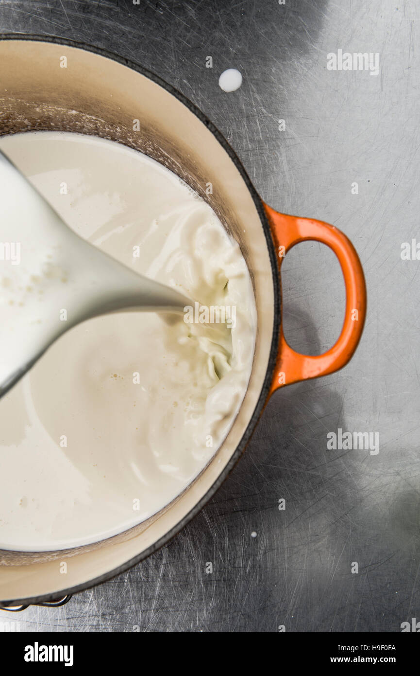 Milk pouring into pot Stock Photo - Alamy