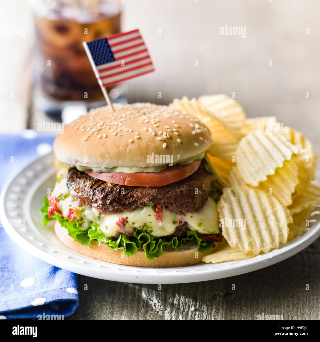 Cheeseburger and potato chips with American flag Stock Photo - Alamy
