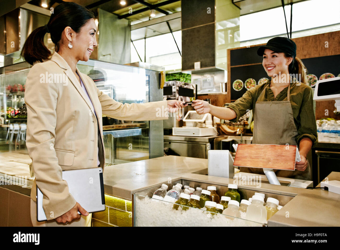 Businesswoman paying cashier in food court with credit card Stock Photo ...