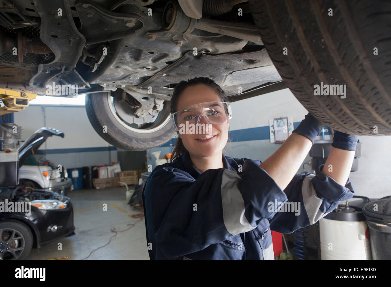 Smiling Hispanic mechanic repairing car Stock Photo - Alamy